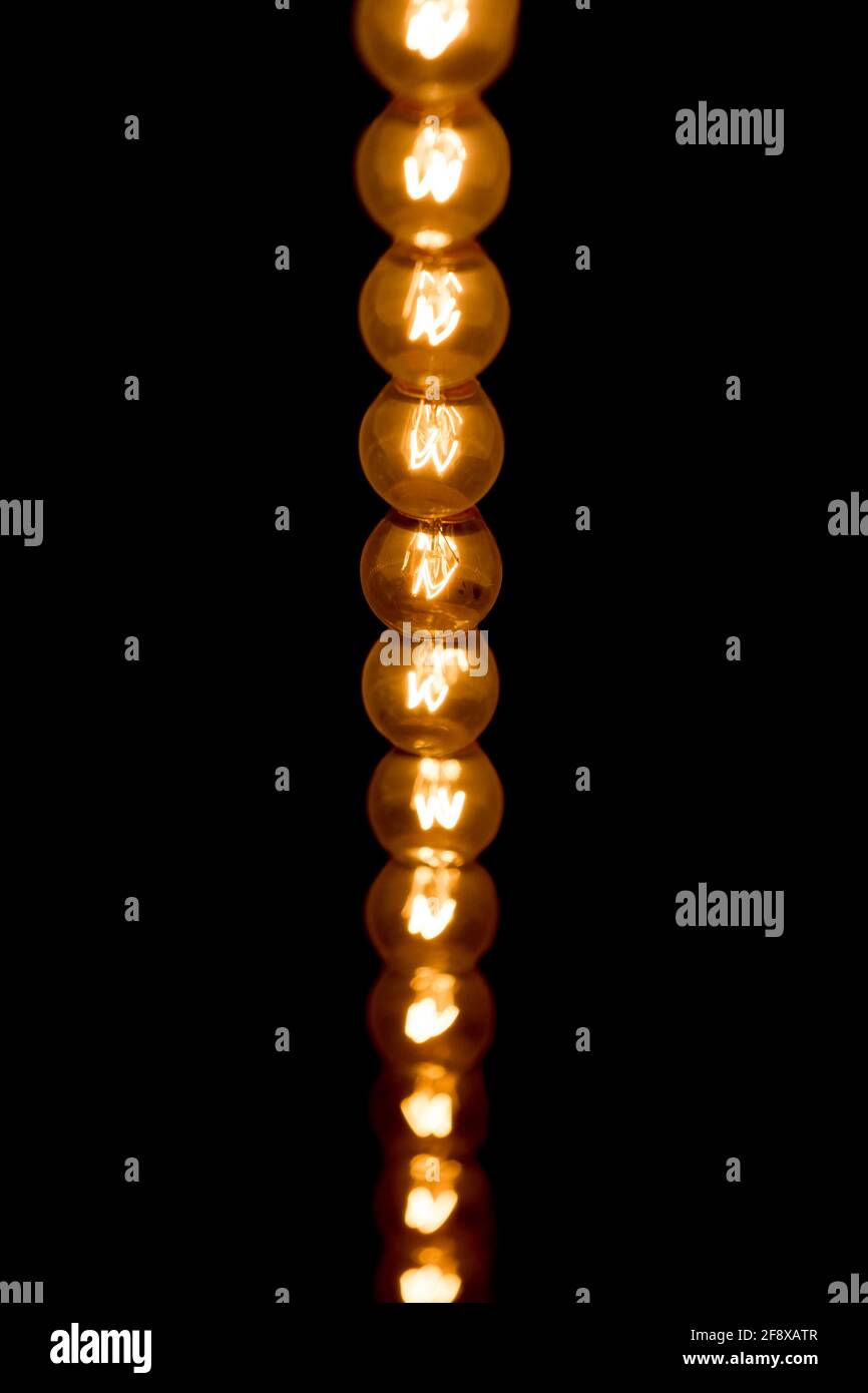Many light bulbs shining bright light in dark line row. Plenty ...
