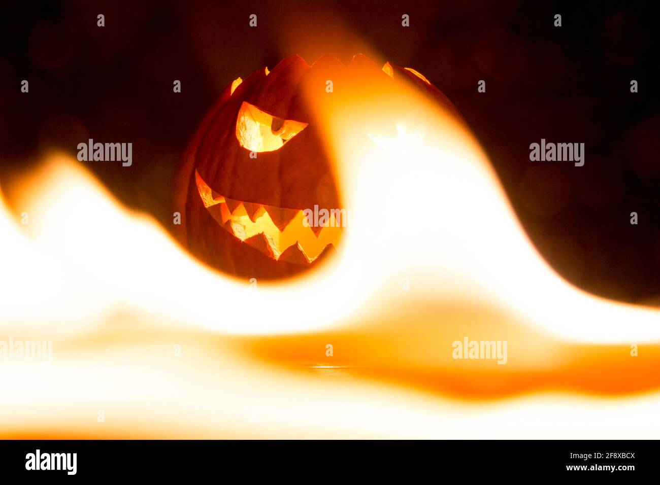 Spooky carved halloween pumpkin on hot burning hell fire flames. Big ...