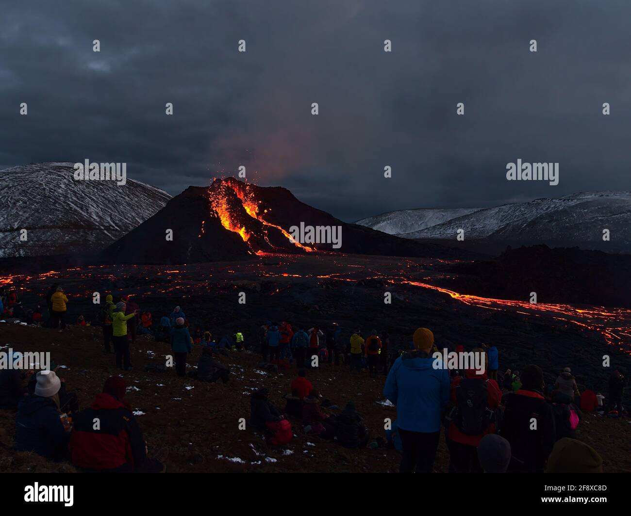 Large group of people watching a volcanic eruption at Fagradalsfjall in ...