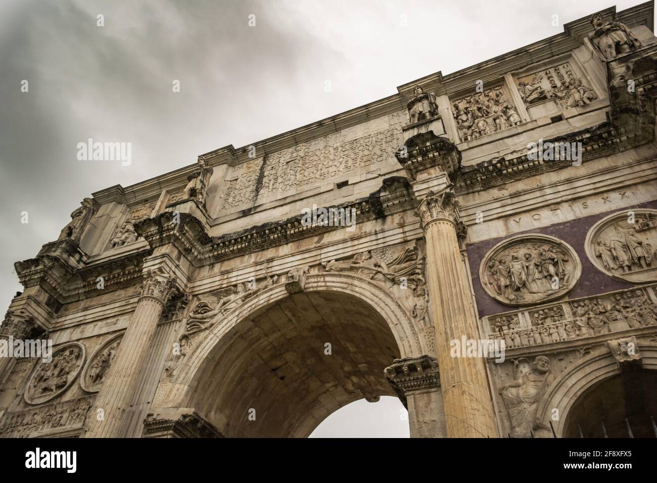 Low angle shot of the Arch of Constantine under a cloudy sky in Rome ...