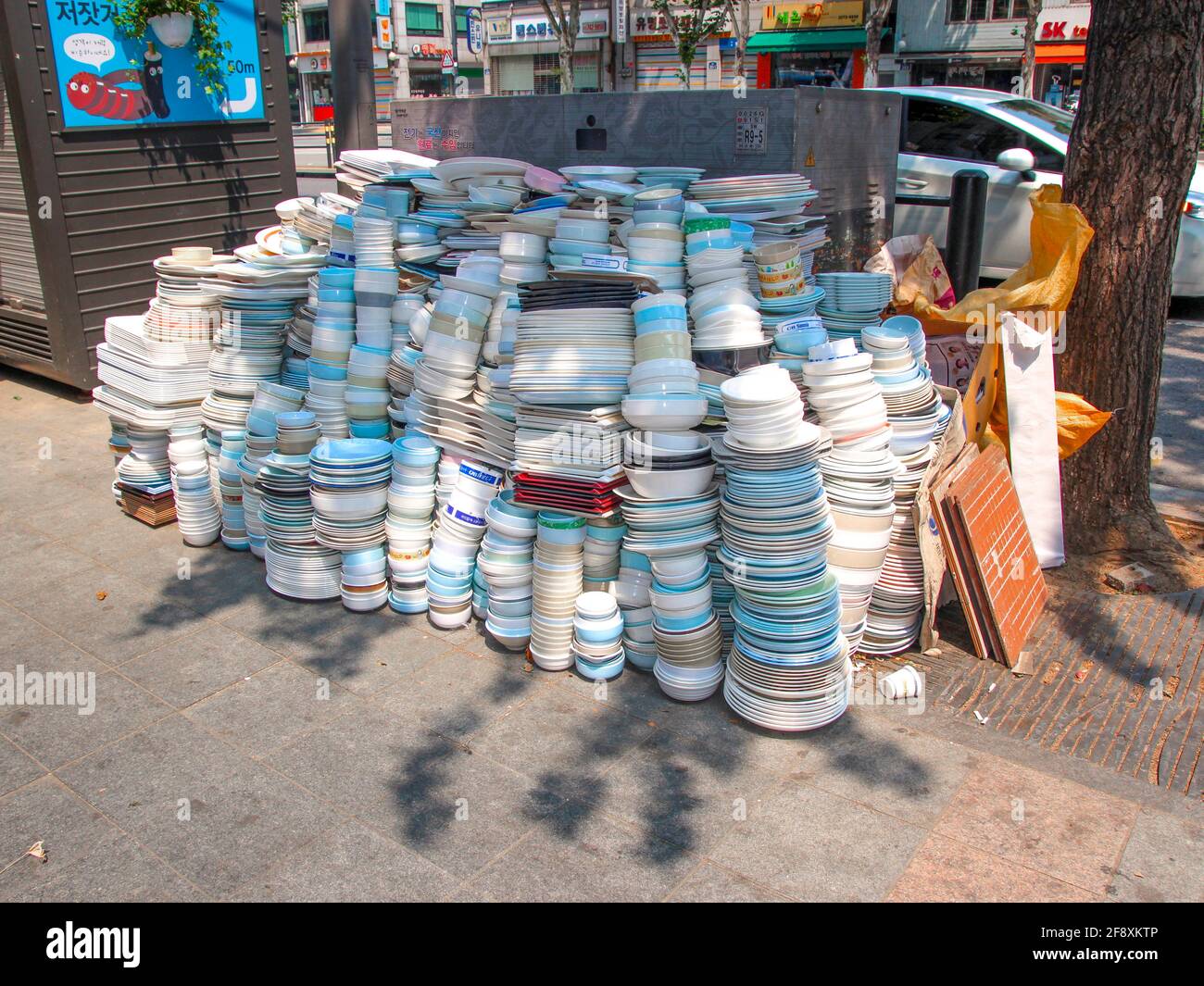 A huge stack of basic dishes for sale, on a sidewalk. In Seoul, South ...