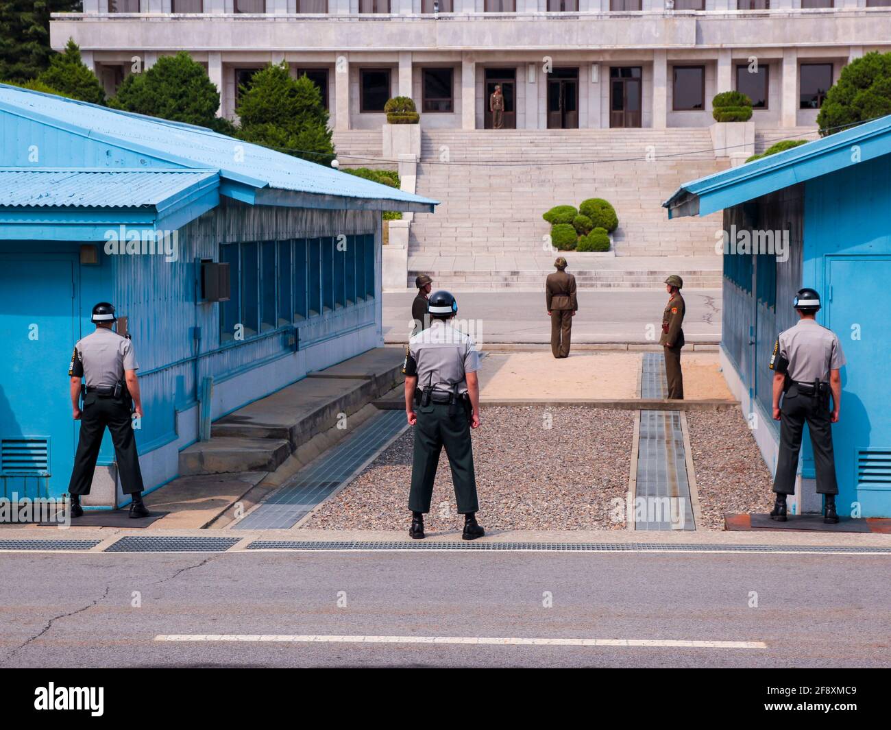 Guards from North and South Korea stand next to the light blue UN ...