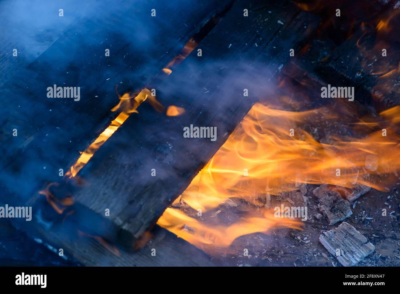 Spurts of flame. Burning wooden boards and logs. The bright flame of ...