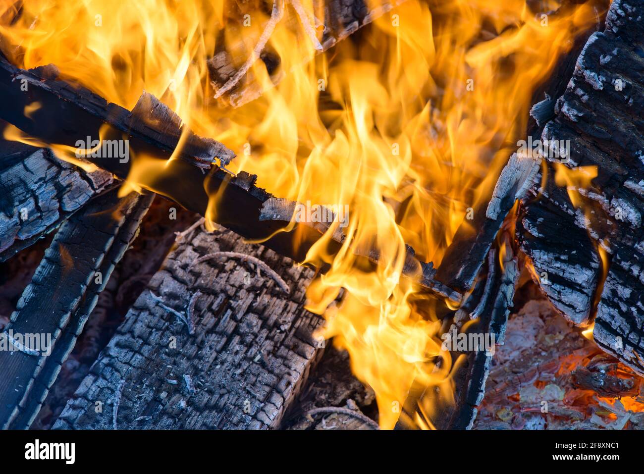 Spurts of flame. Burning wooden boards and logs. The bright flame of ...