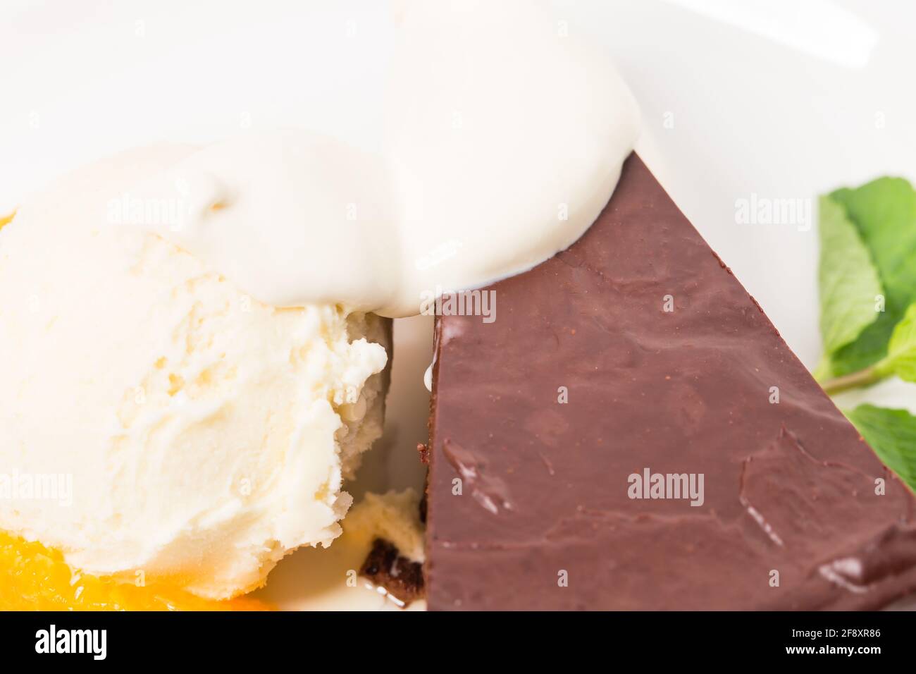 Chocolate cake with ice cream scoop on a sliced orange and mascarpone ...
