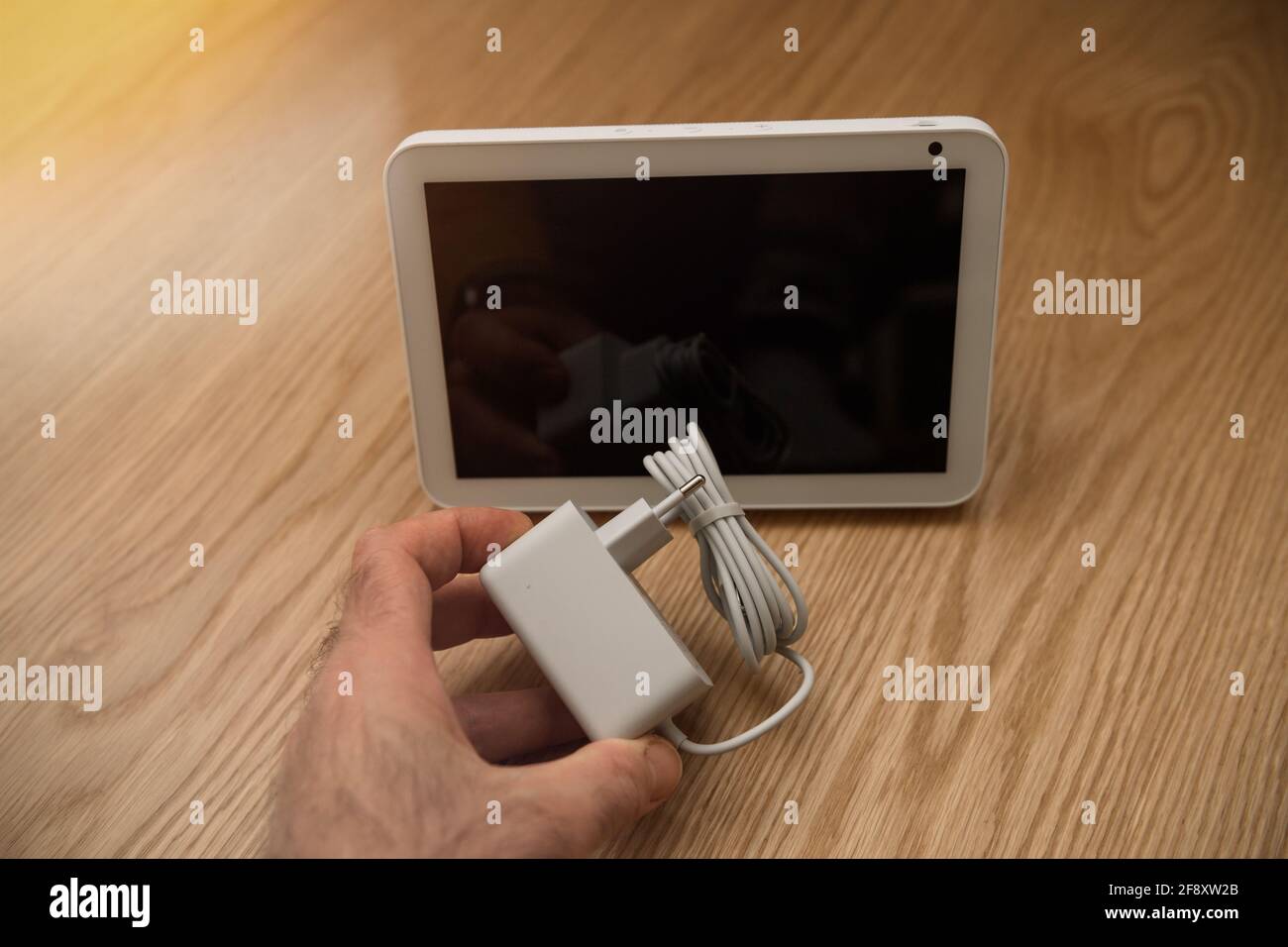 Male hand holding the power supply unit of new Amazon Echo 8 Stock ...