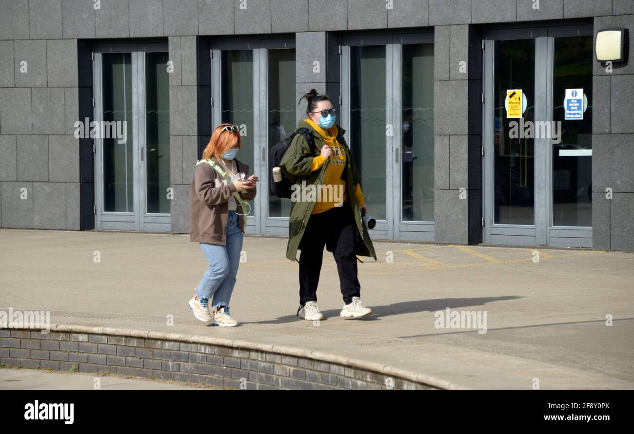 Two women, in masks, overdressed on sunny day Stock Photo - Alamy