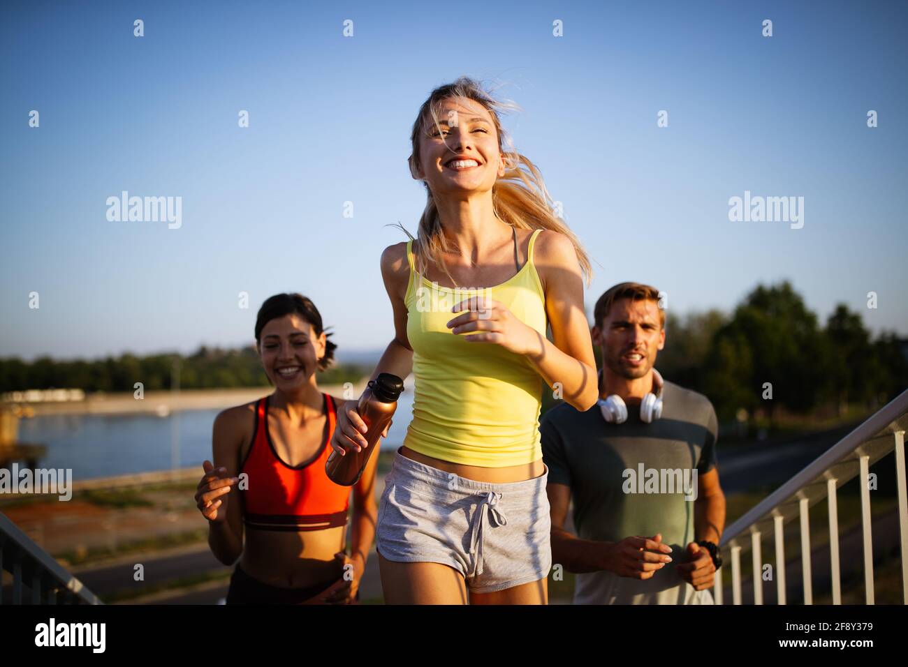 Early morning workout. Happy people running across the bridge. Living ...