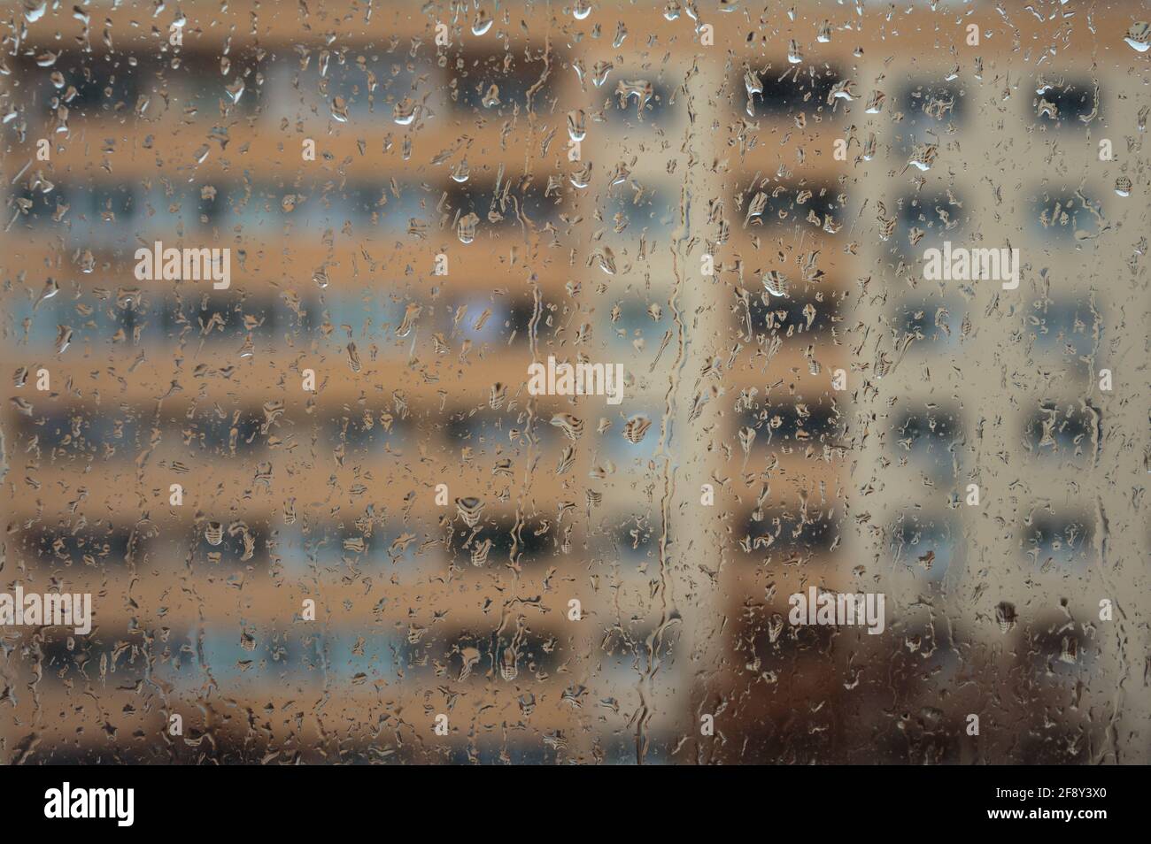 Rain drops on window, reflecting city buildings Stock Photo - Alamy