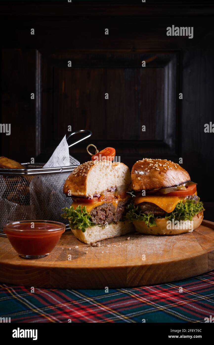 Delicious cut in a half cheeseburger and crispy village potatoes with ...