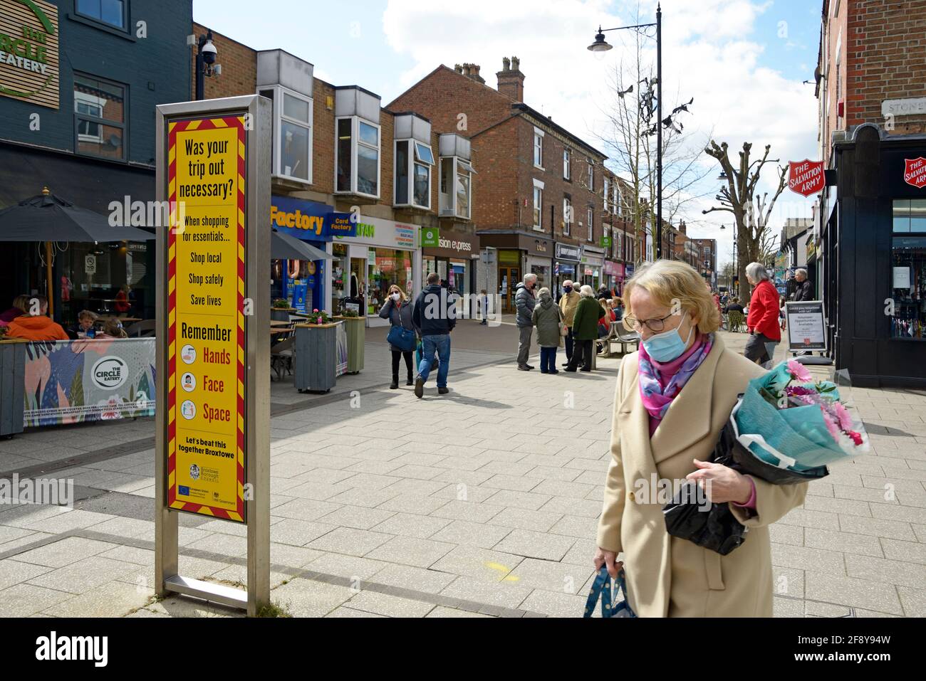 Warning sign, & shoppers after lockdown is lifted, lady with flowers ...