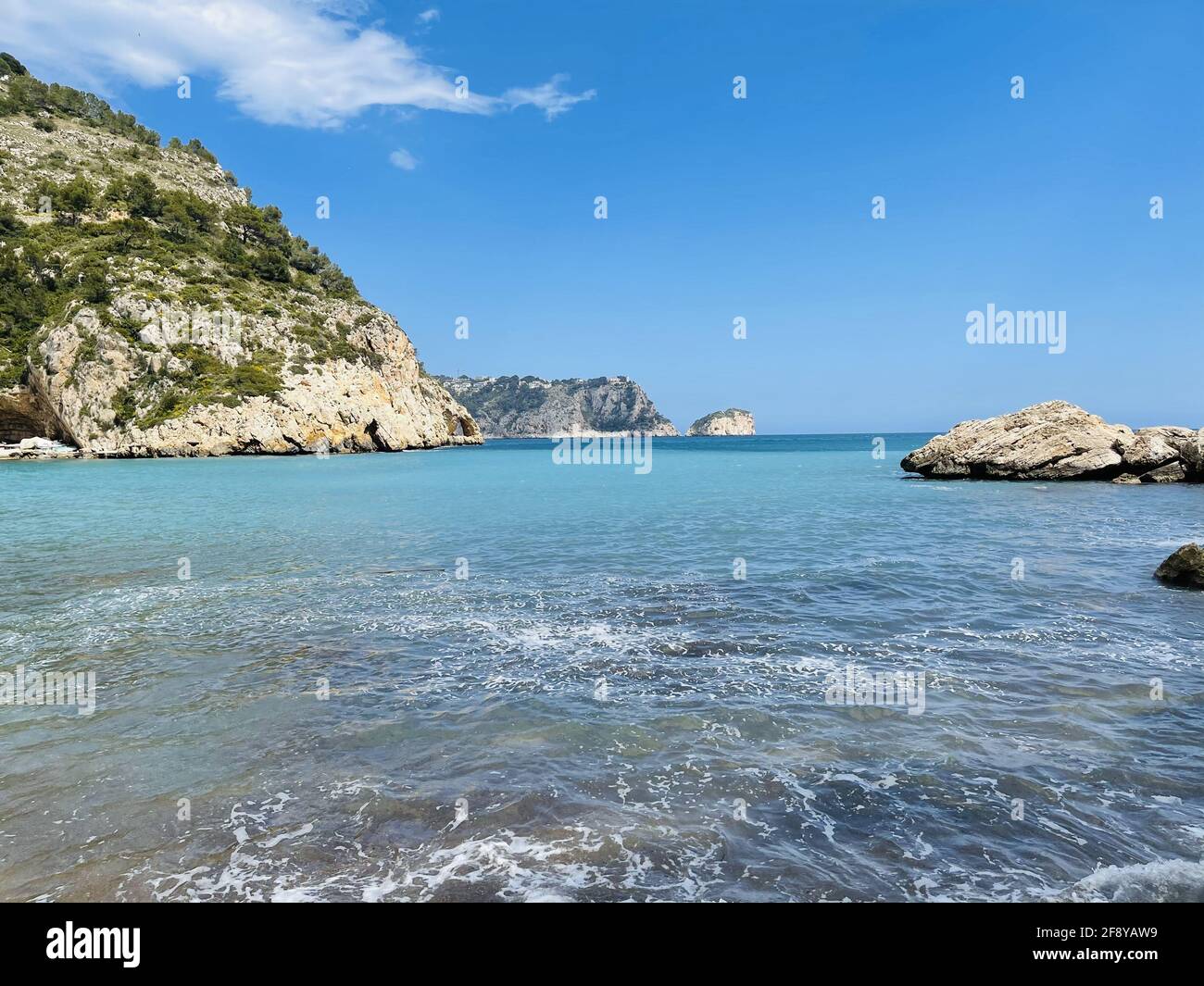 Gorgeous shot of the Granadella Beach in Spain with a deep bright blue ...