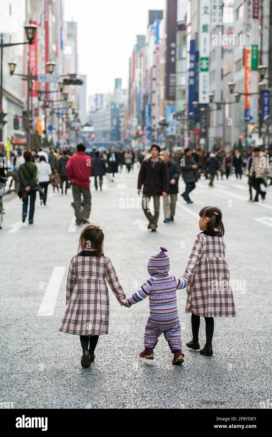 Young Japanese well dressed children holding hands walking along ...