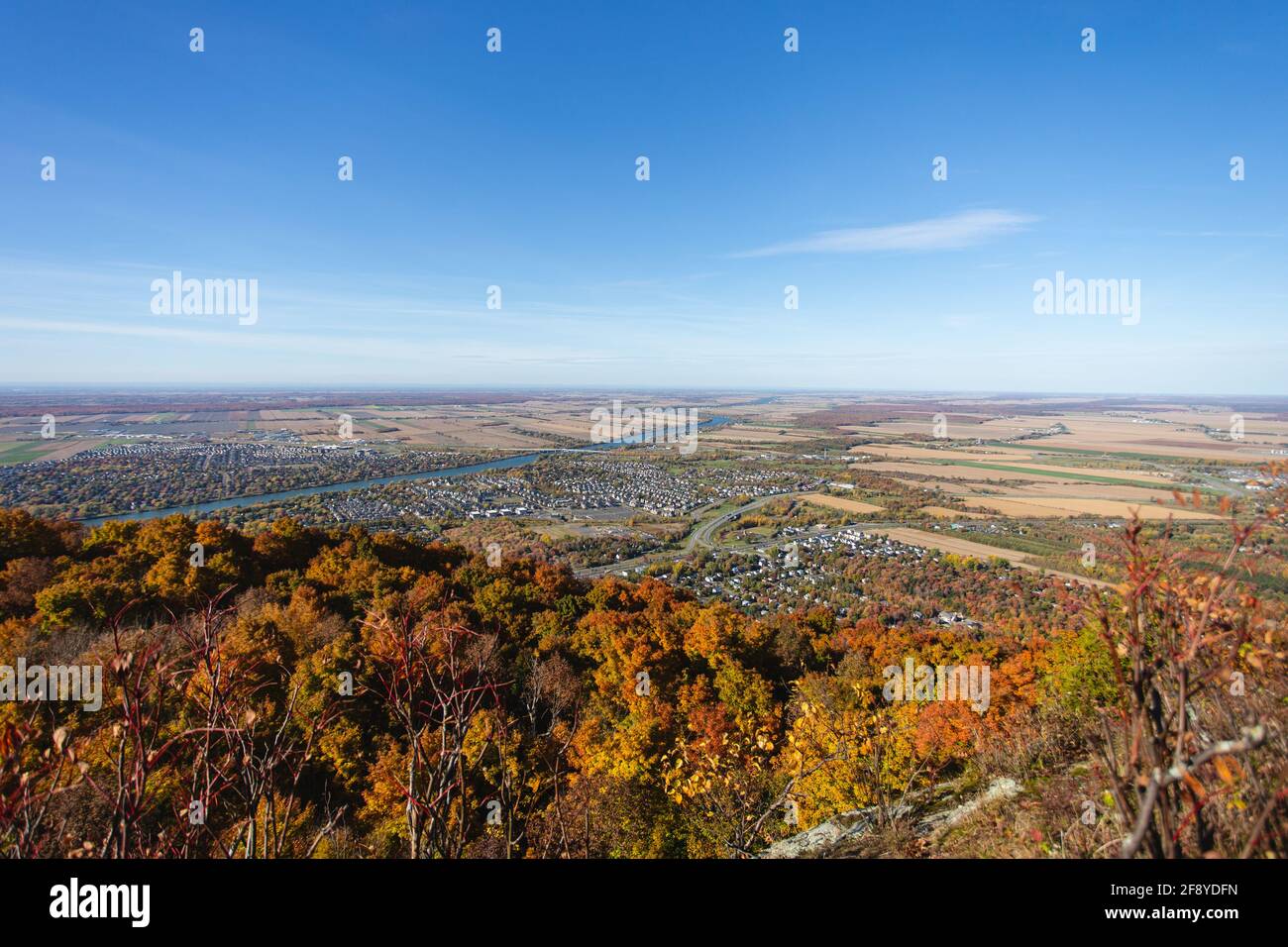 top of a hill with a colourful forest below Stock Photo - Alamy