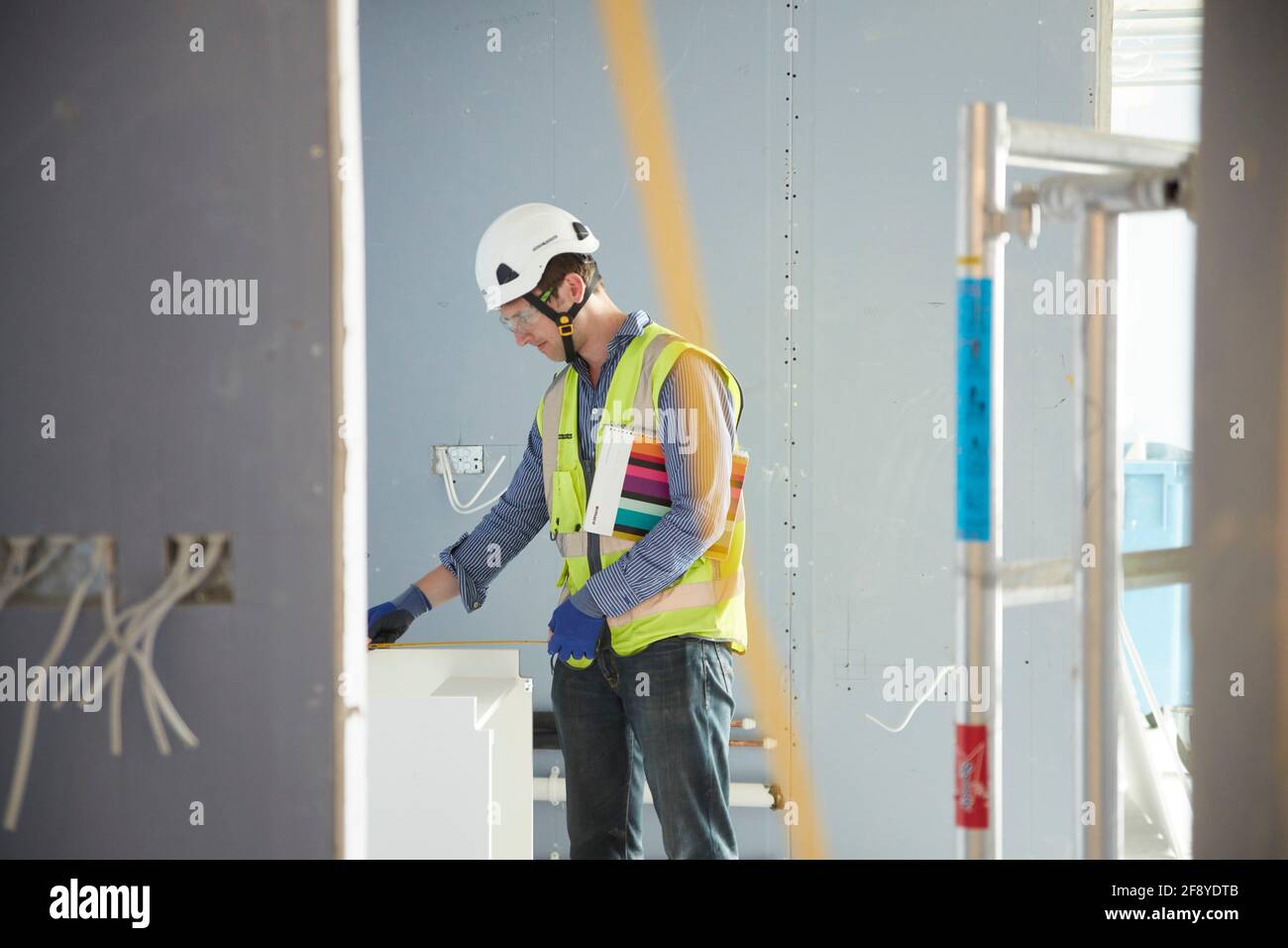 site manager measures basin unit on building site Stock Photo - Alamy