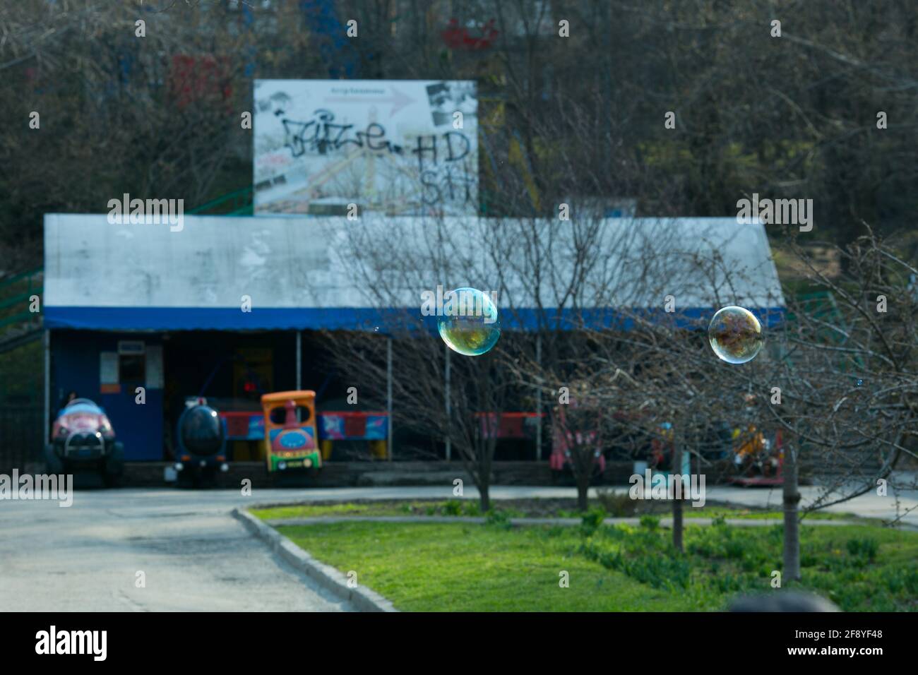 Bright big soap balls in the park. Children inflate soap bubbles and ...