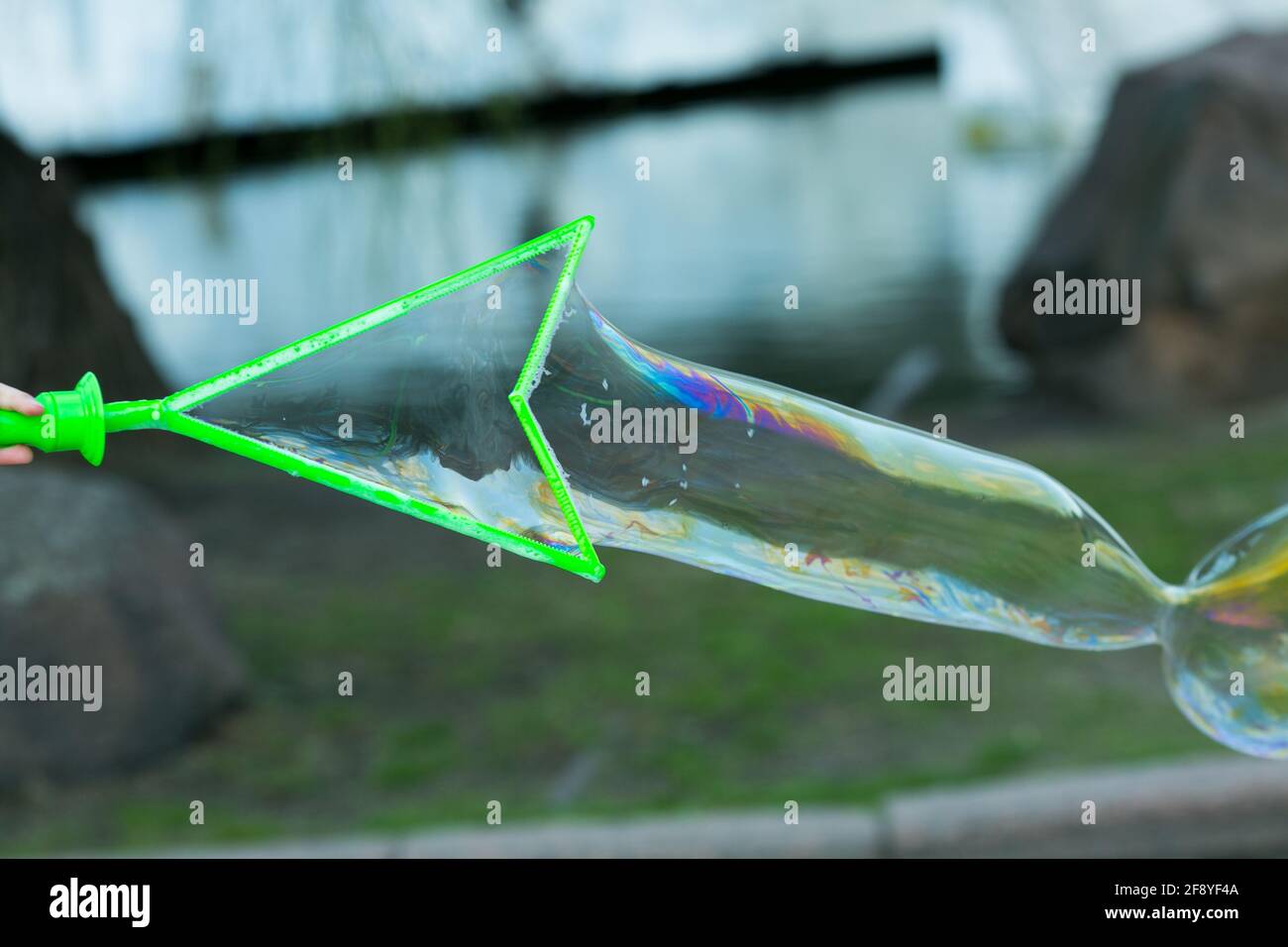 Bright big soap balls in the park. Children inflate soap bubbles and ...