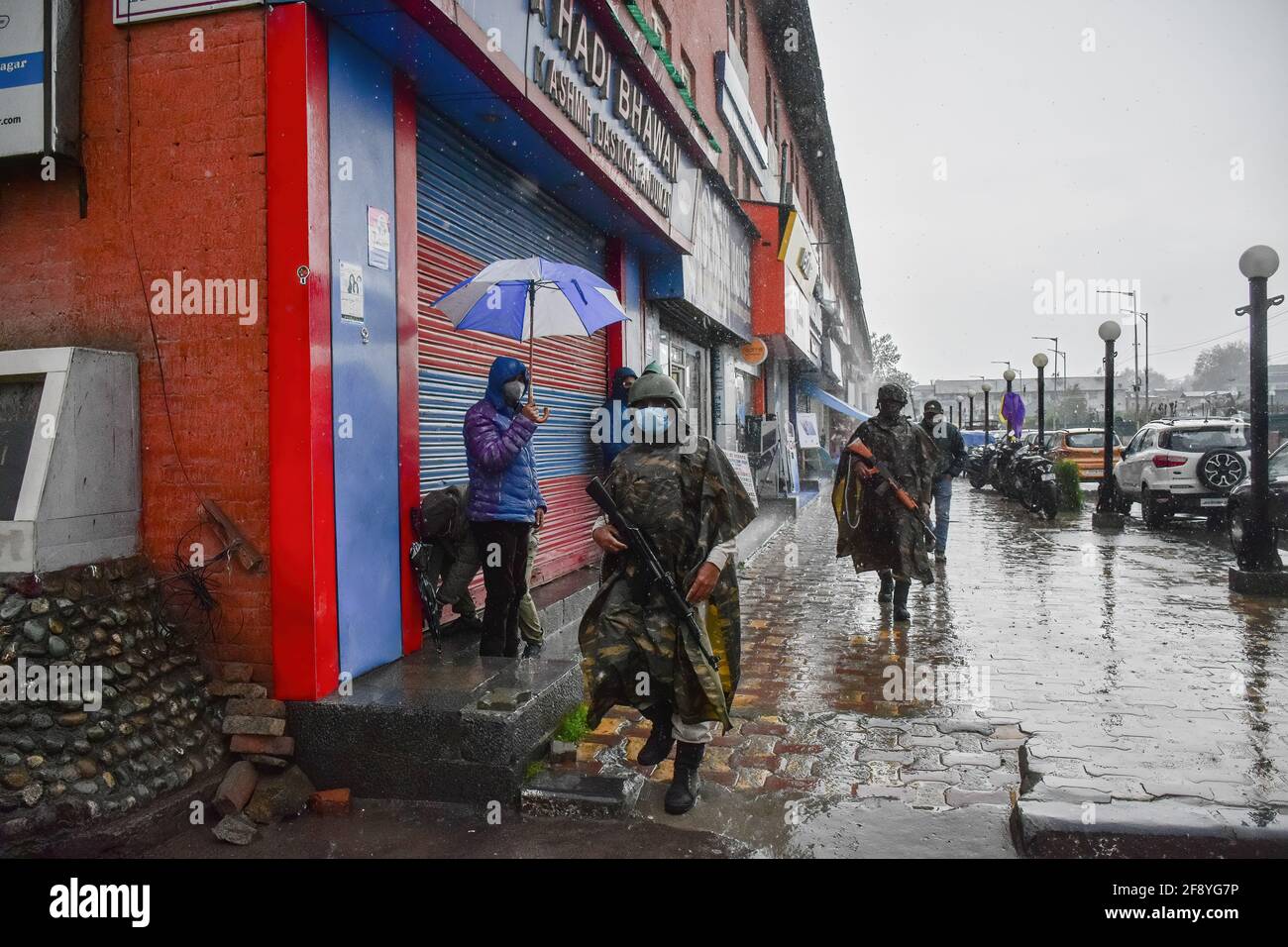 Paramilitary troopers seen patrolling during the rainfall in Srinagar ...