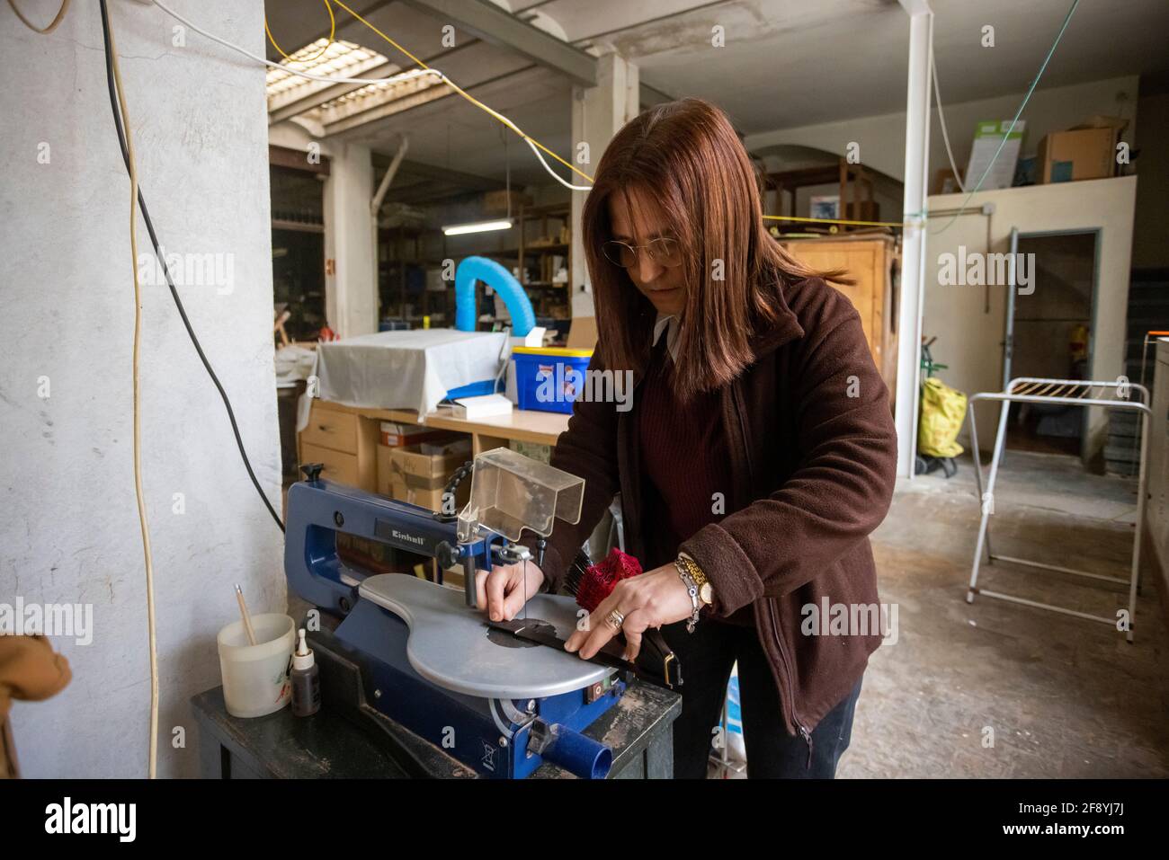 Closeup shot of a Spanish woman cutting a fan working at a hand fan ...