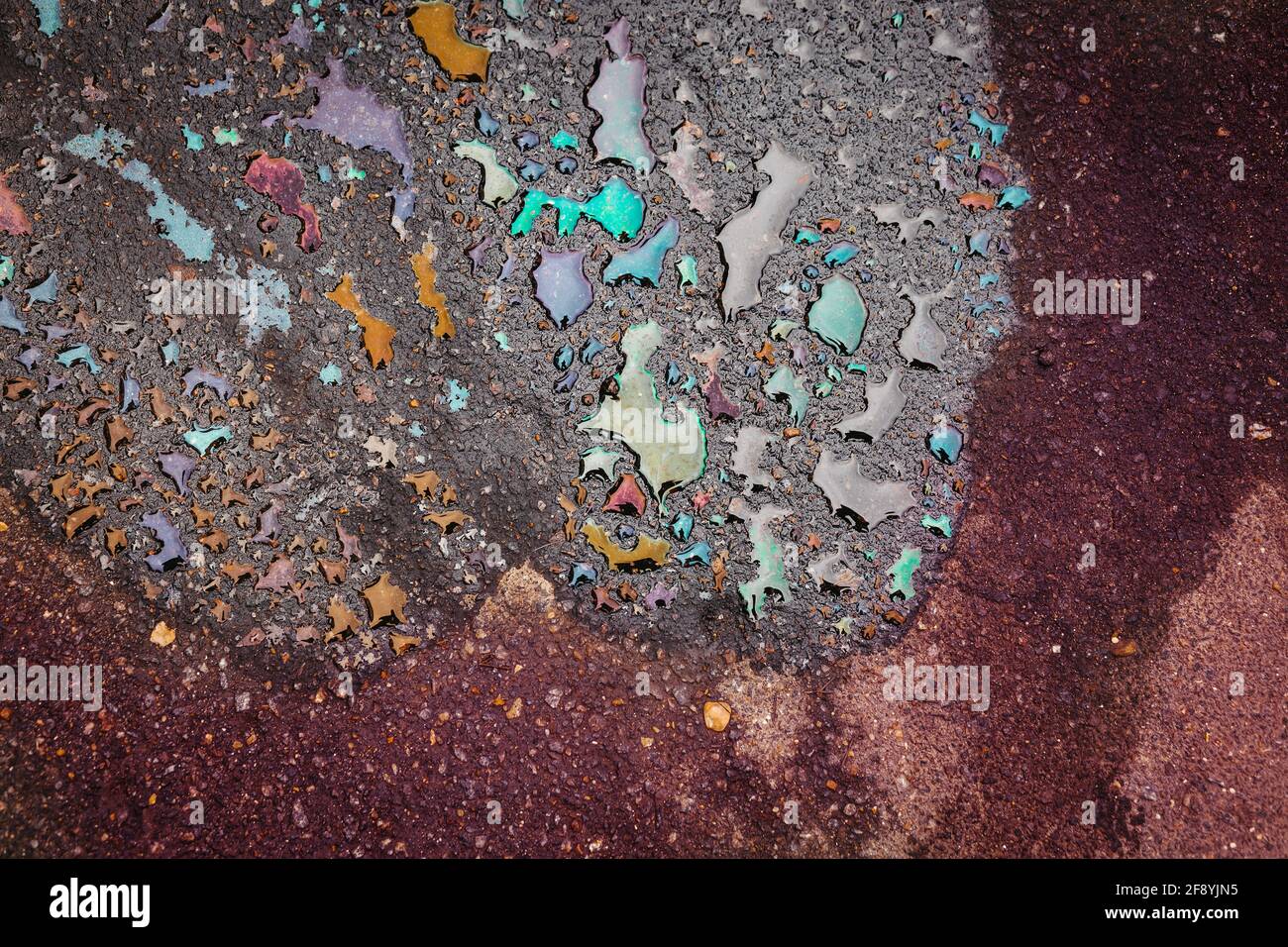 Oil stain on Asphalt road after rain. Multi-colored oil stain on the ...