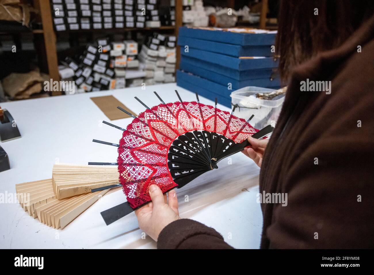 Closeup shot of a Spanish woman working at a hand fan design workshop ...