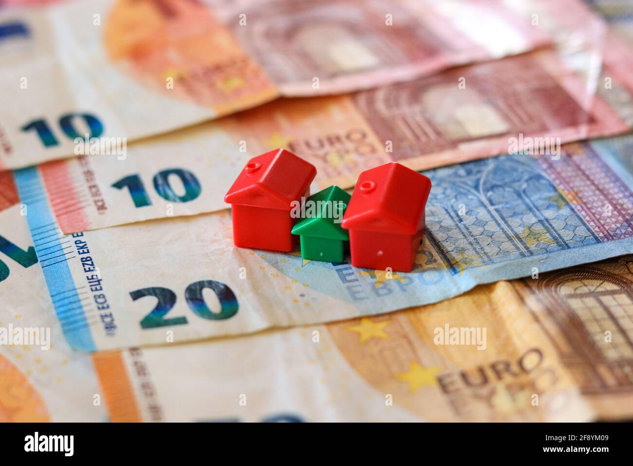 table covered with Euro banknotes with houses on top. Real estate ...