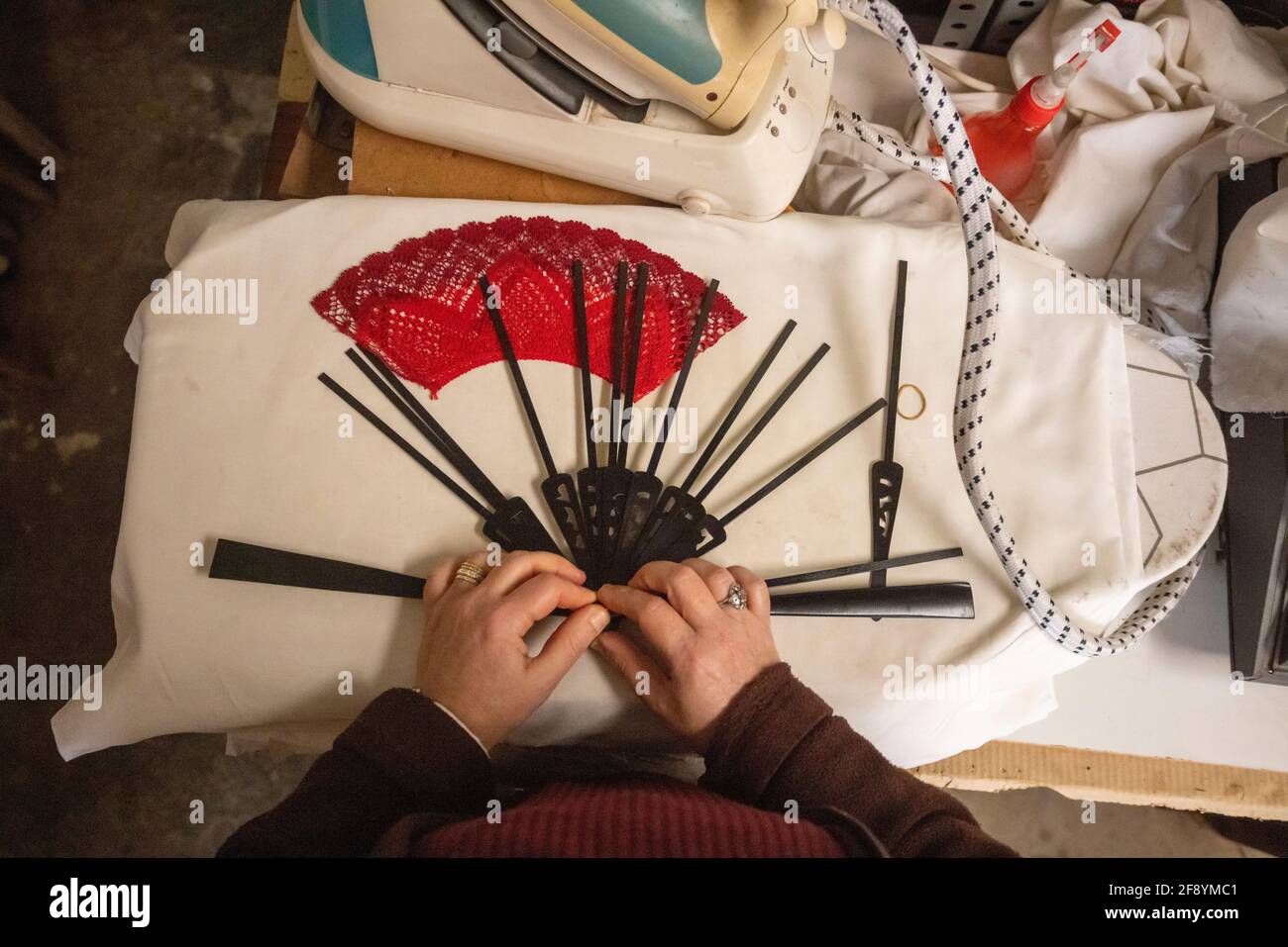Top view of a Spanish woman's hands handcrafting a hand fan at the ...