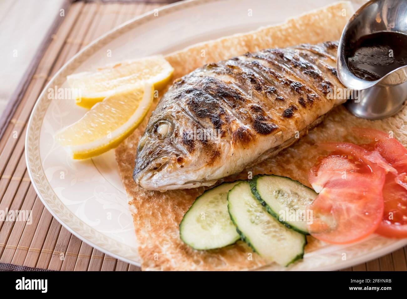 Roasted dorada fish with vegetables on wooden background Stock Photo ...