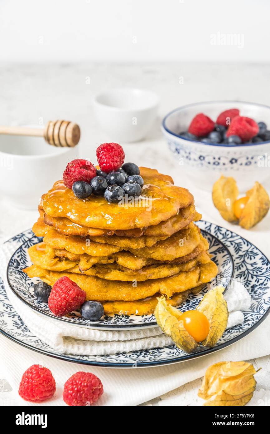 Pile of vegan pancakes with berries and syrup on white background ...