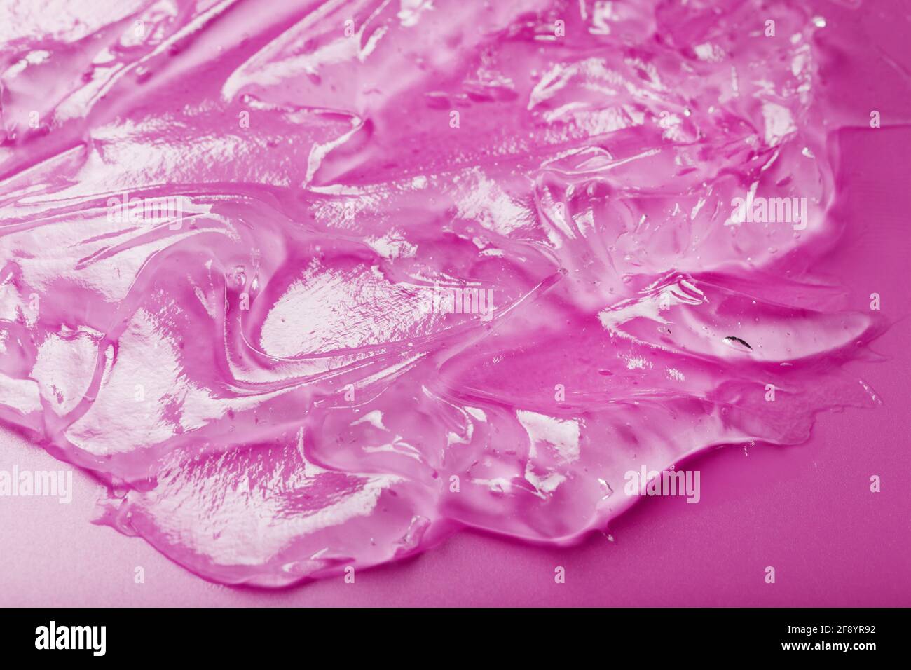 Transparent liquid gel on a pink background with free space. Antiseptic ...