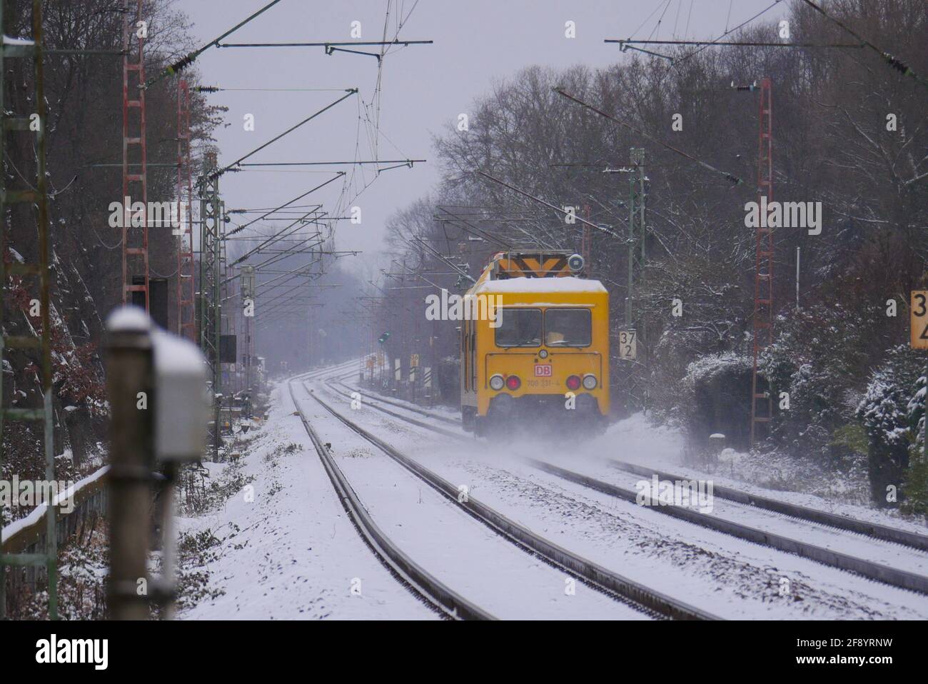 Snowy train tracks in winter with yellow locomotive pushing the snow ...