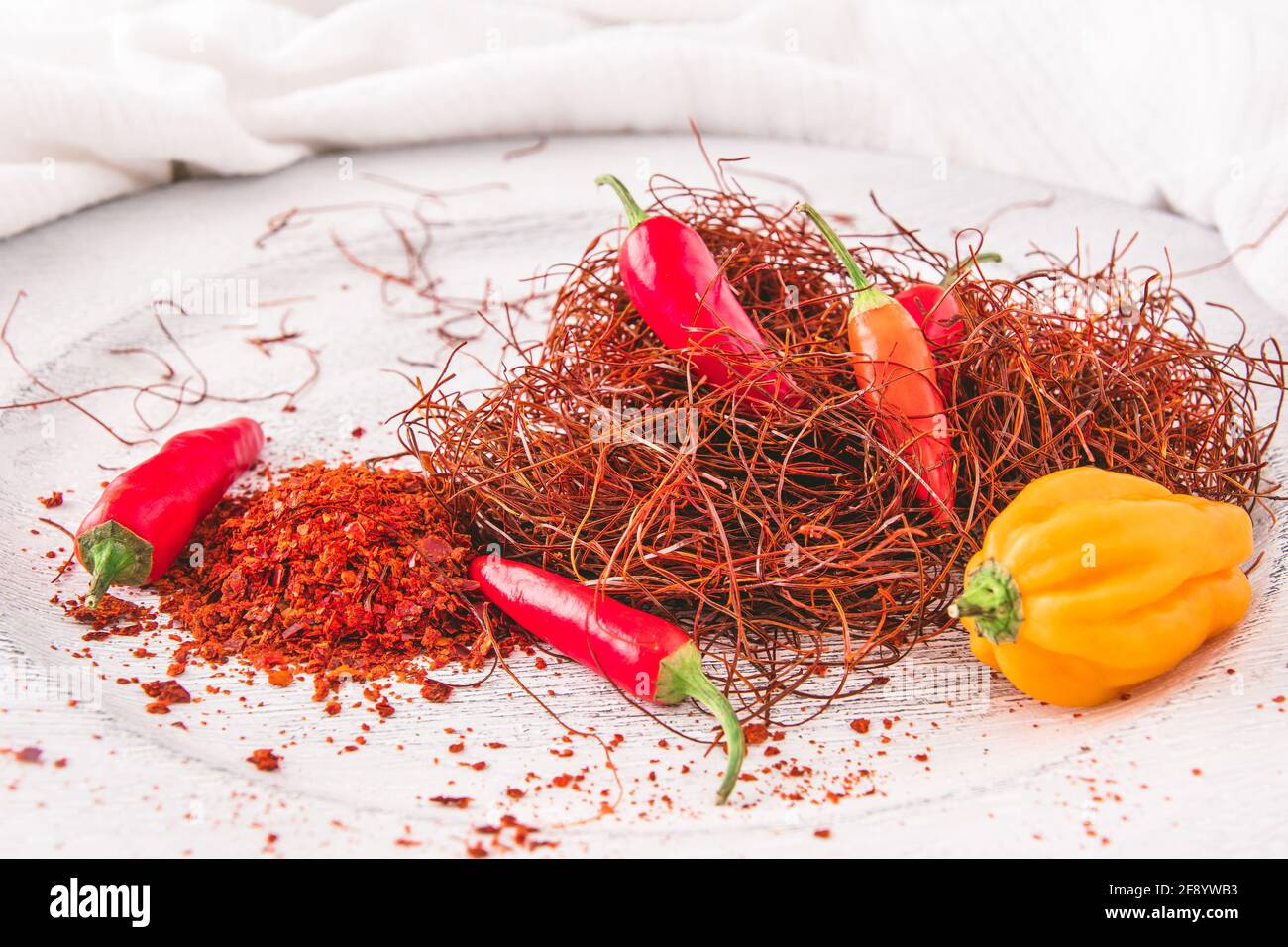 Chili pods, flakes and threads on white background Stock Photo - Alamy