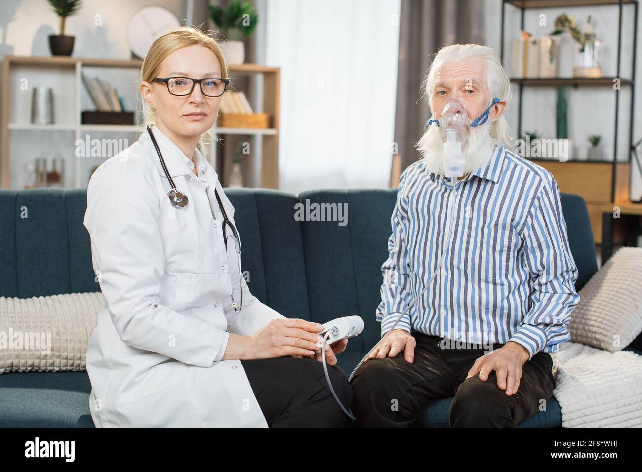 Portrait of senior grey-haired bearded man patient wearing nebulizer ...