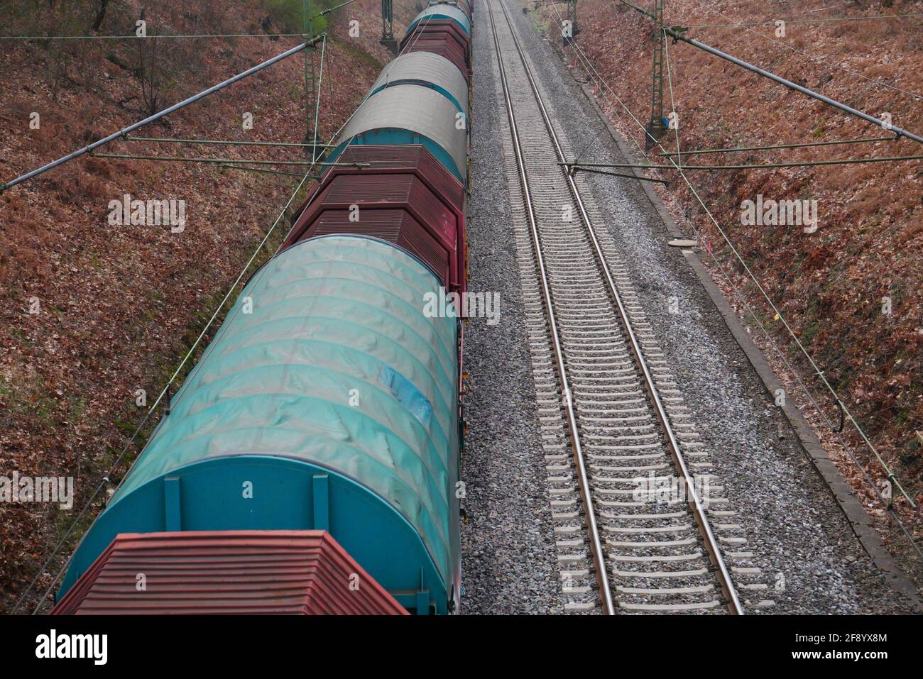 railway line with blue tarpaulin wagons and brown rusty sliding roof ...