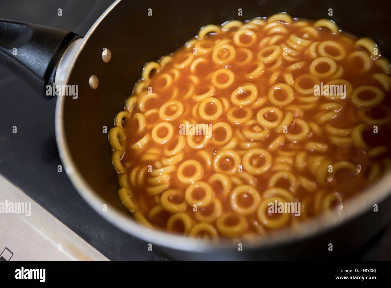 Tinned spaghetti hoops cooking in a pan on an electric hob Stock Photo ...