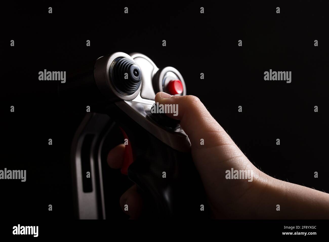 Finger on a trigger of aircraft stick controller, close up on black ...