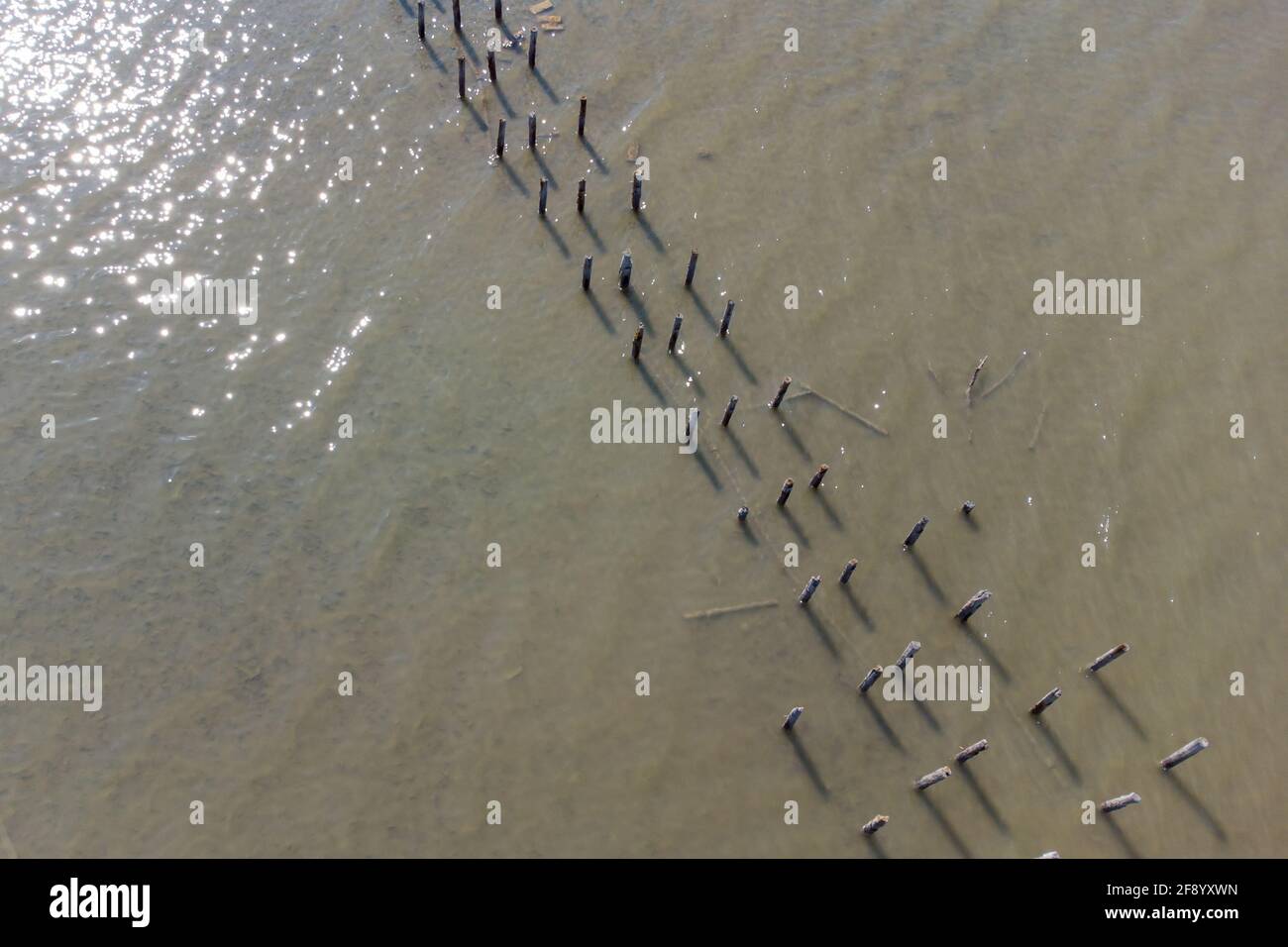 A stone spit and wooden pillars on the surface of the Kuyalnik estuary ...