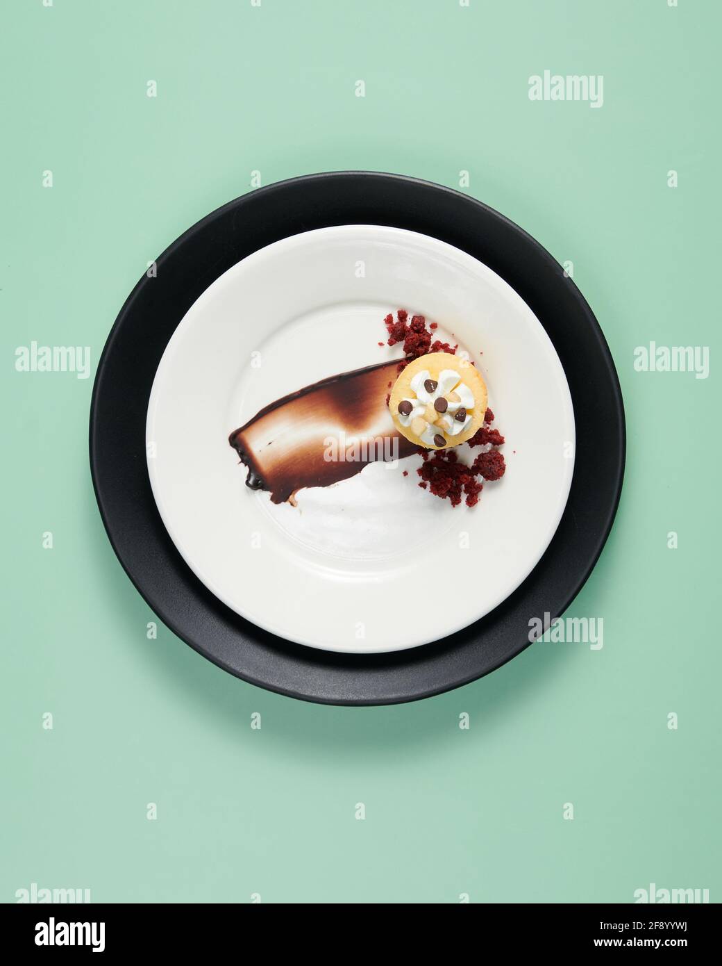 Vertical top view of a small cake served on a decorated plate on a ...