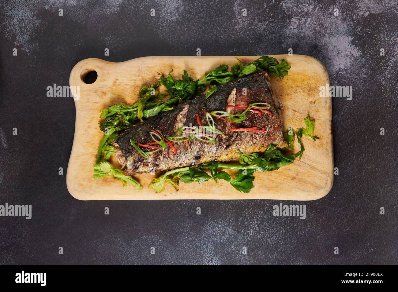 Top view of seasoned cooked fish served on a wooden plate Stock Photo ...