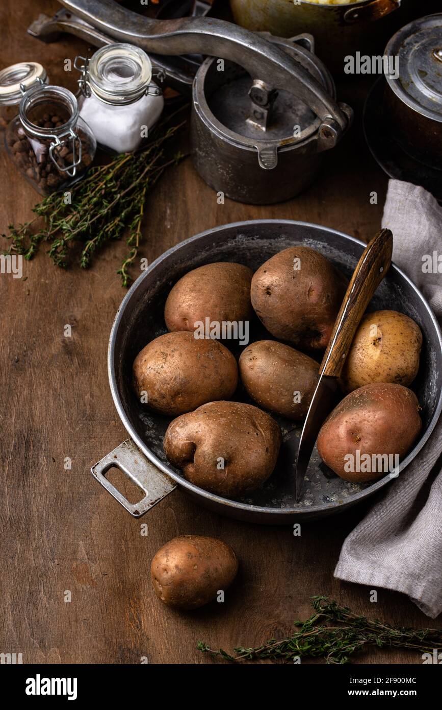 Raw uncooked potato in old vintage pot Stock Photo - Alamy