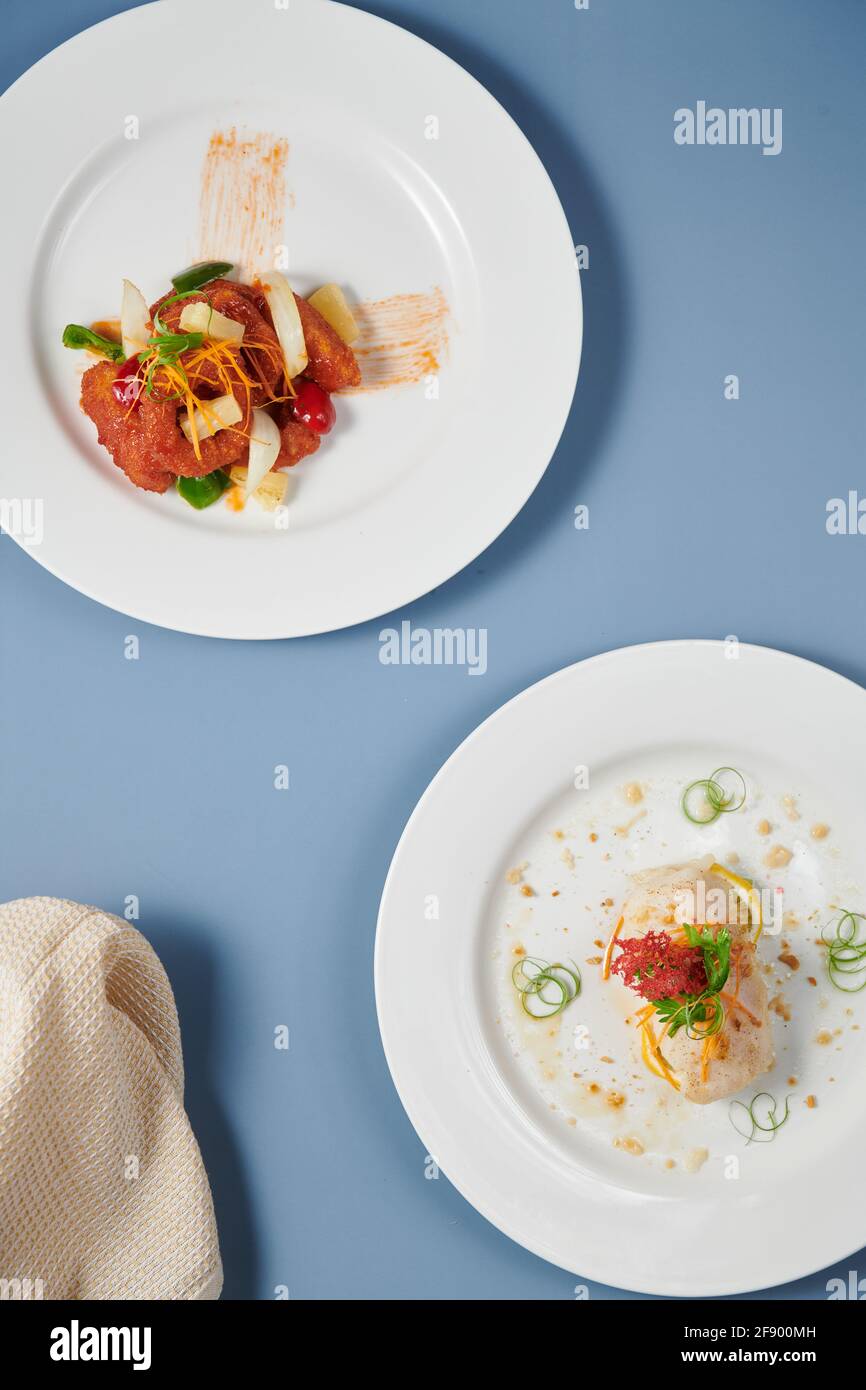 Vertical top view of decorated dishes served on white plates Stock ...