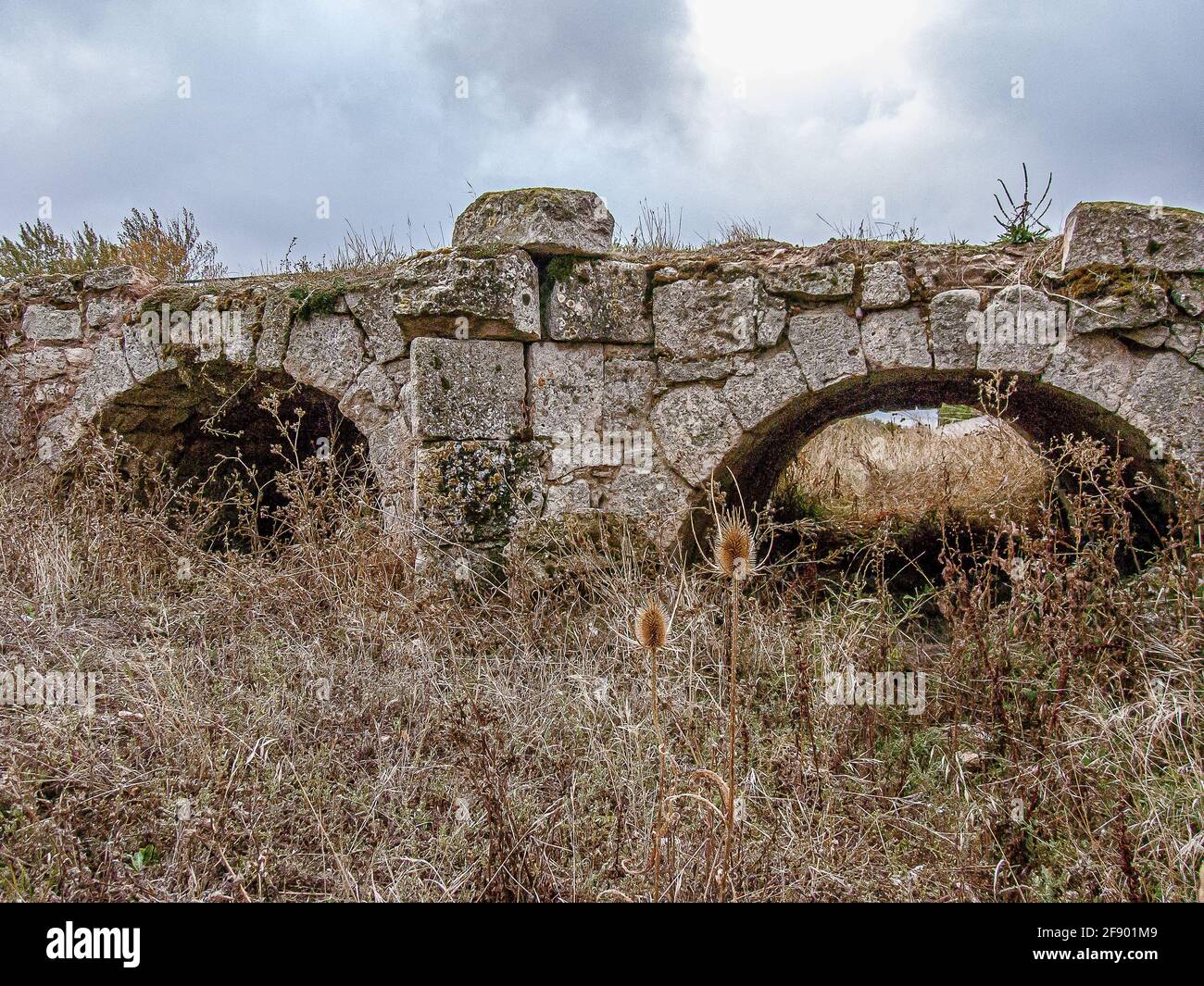 medieval stone bridge among weed in a dried riverbed, Hornillos del ...
