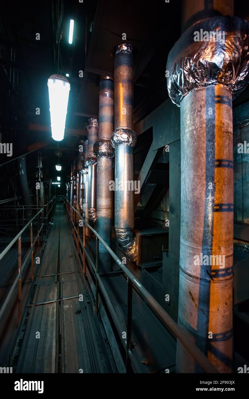 Steam power plant. View on boiler pipes in thermal insulation. Bridge ...