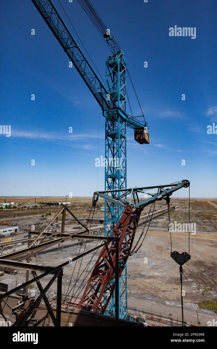 GRES-1 thermal power station. Two construction cranes on steppe (desert ...