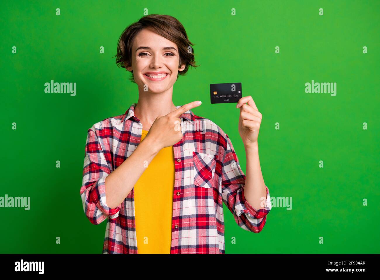 Photo of optimistic cute short hairstyle girl pointing card wear orange ...