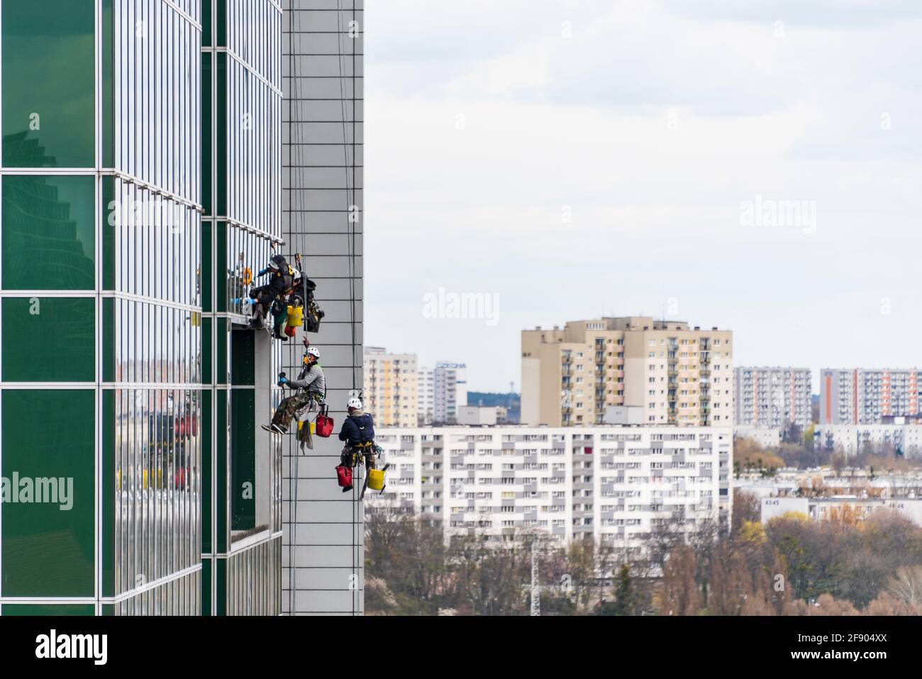The group of workers cleaning windows and the glass facade of a modern ...