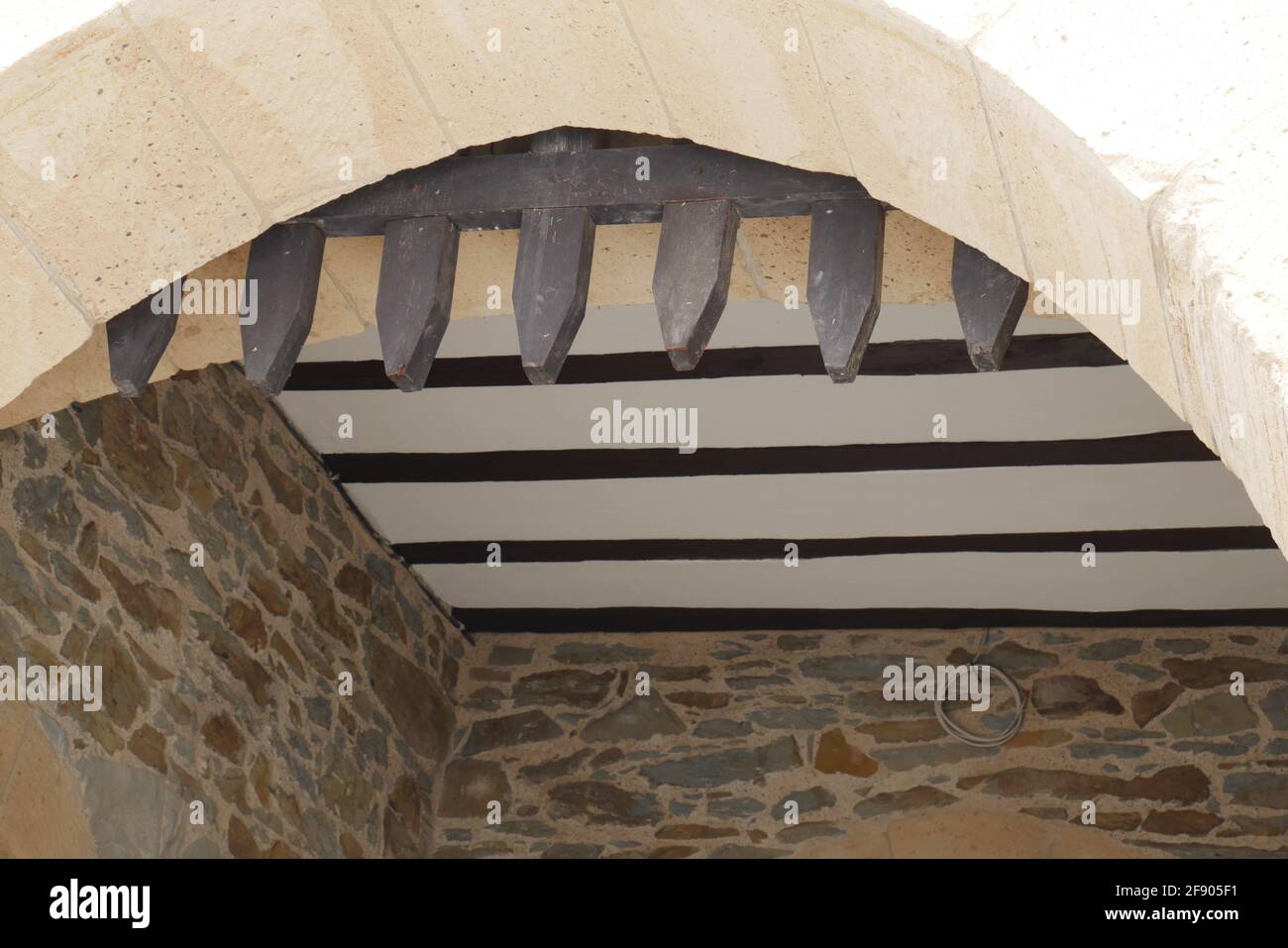 Close up of a medieval open portcullis behind a stone archway of a ...