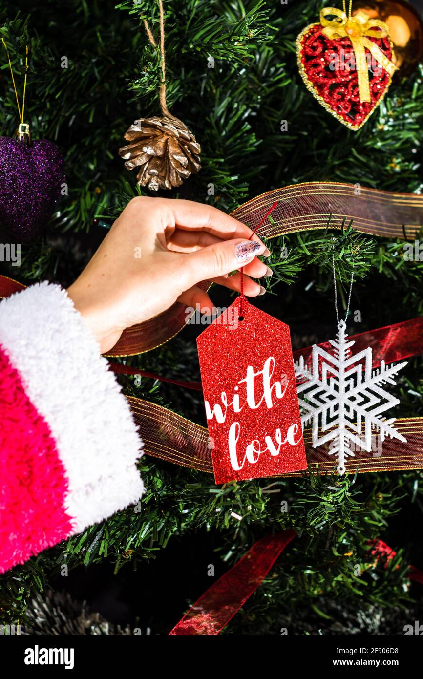 Decorating Christmas tree, hand putting Christmas decorations on fir ...