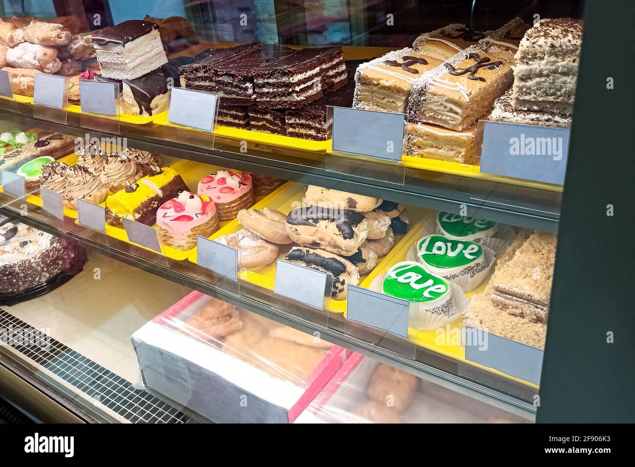 Various multicolored cakes on store shelves close up Stock Photo - Alamy
