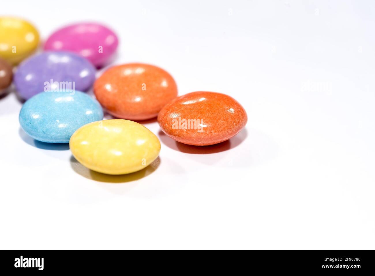 Colorful dragees, close-up on a white background. Chocolate candies in ...